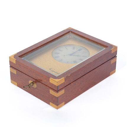 Bonhams : Patek Philippe. A brass and plastic cased quartz desk clock with mahogany presentation ...
