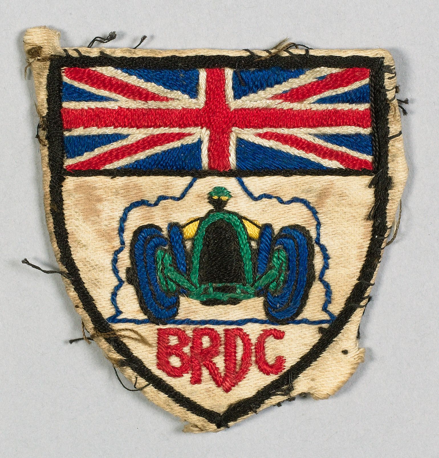 Bonhams Cars : The BRDC cloth overall badge worn by Dr Benjafield,