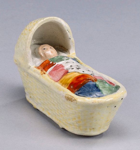 Bonhams : A pearlware model of baby in a cradle, circa 1820,