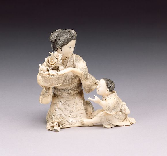 Bonhams : A stained ivory carved as a women and child;