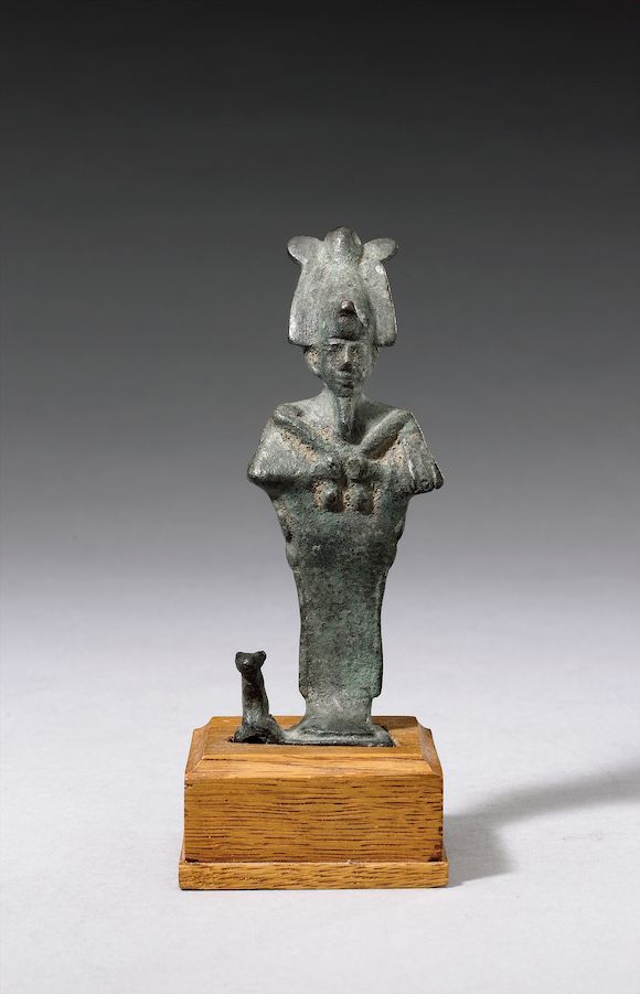 Bonhams : An Egyptian bronze figure of Osiris with a cat