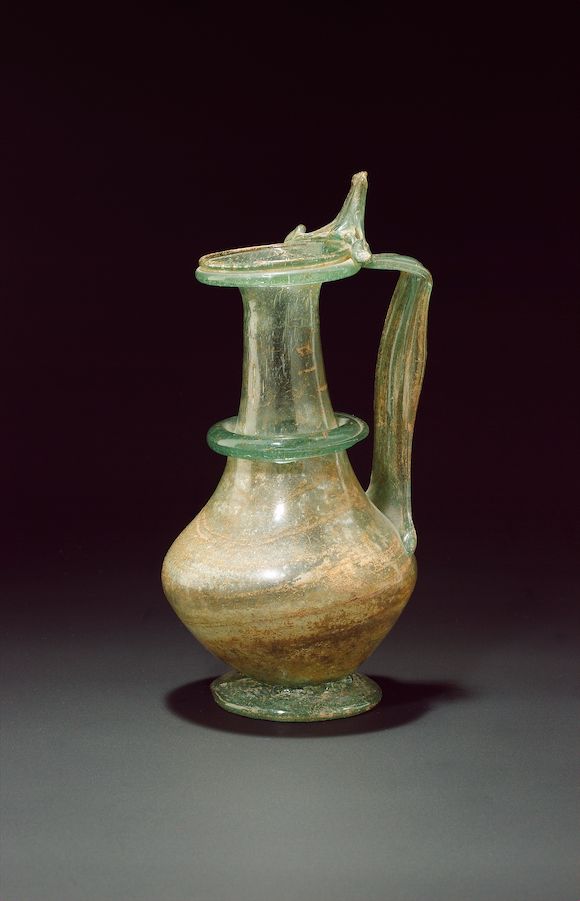 Bonhams : A Roman pale green glass footed jug