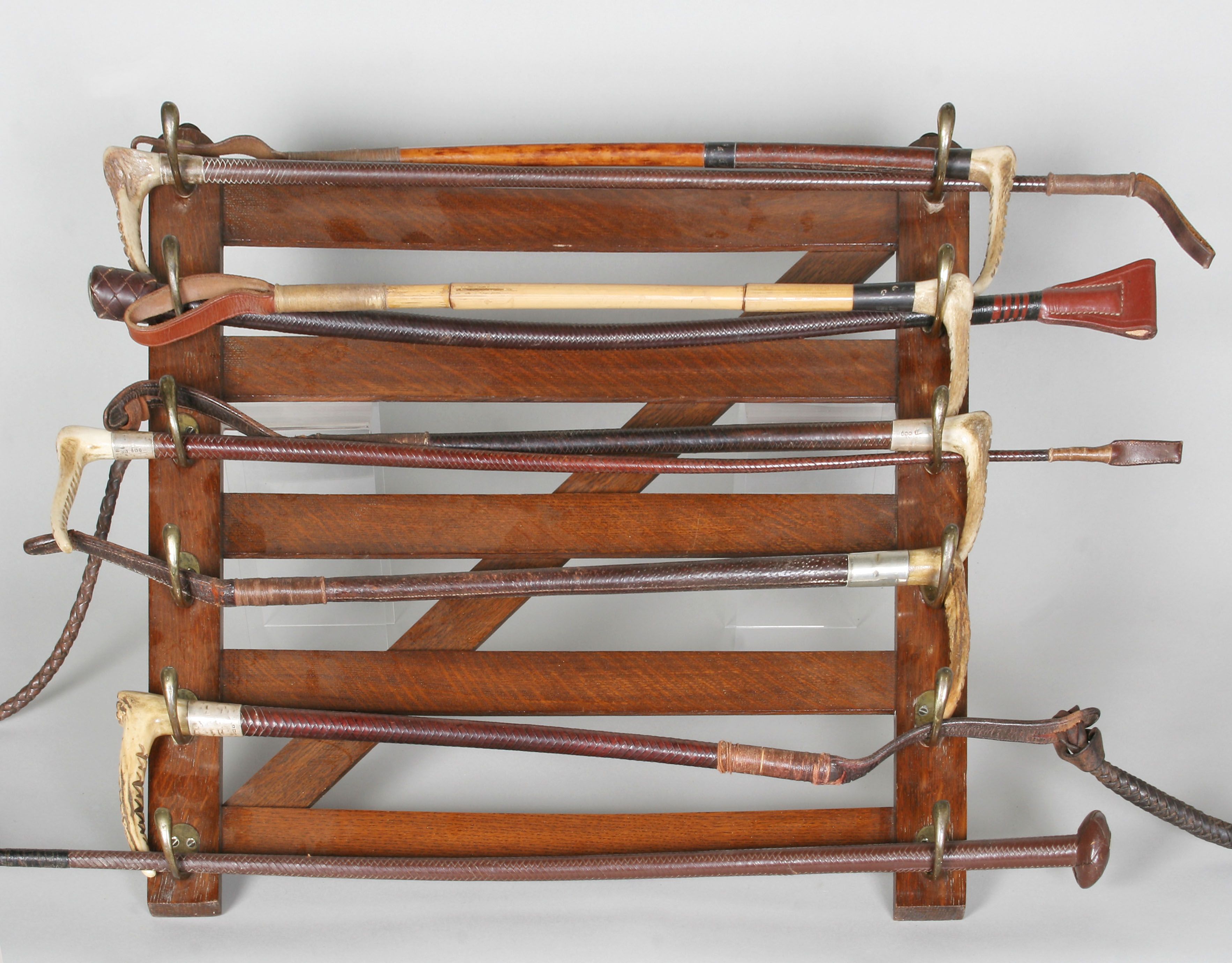 An oak whip rack with a collection of nine riding whips - auctions ...