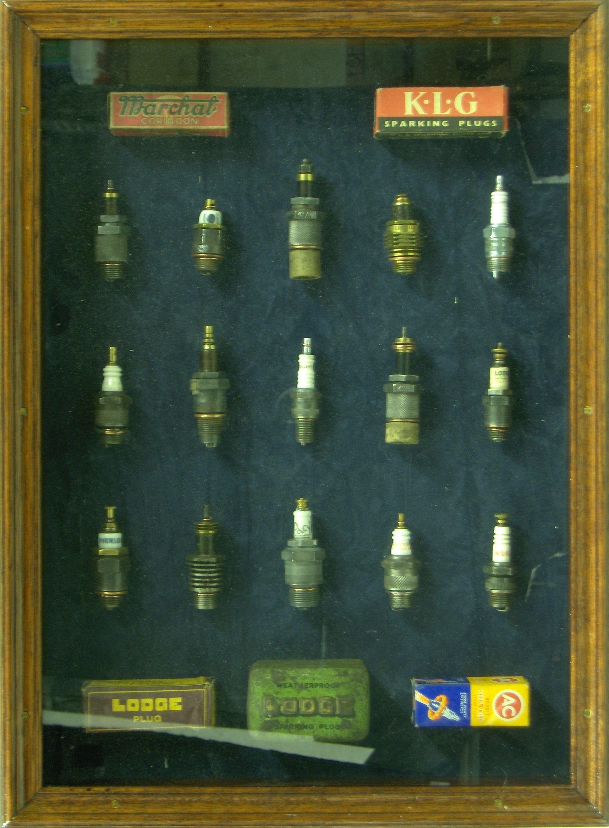 Bonhams Cars : A framed display of early spark-plugs and packaging,