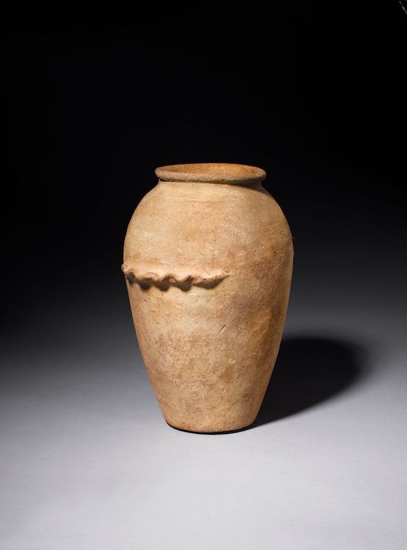 Bonhams : An Egyptian Predynastic buff pottery wavy-handled jar