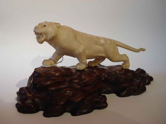 Bonhams : An ivory tiger with wood stand;
