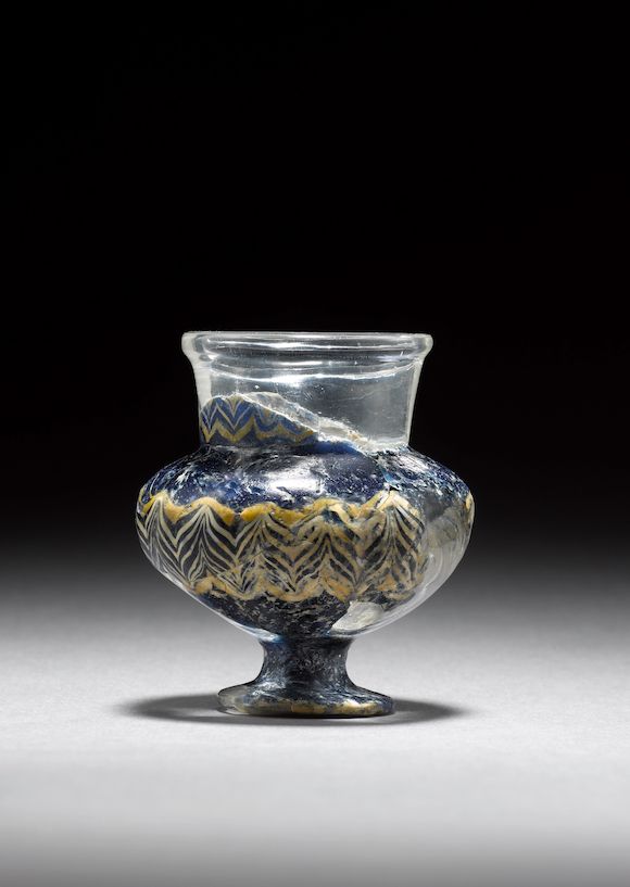 Bonhams : A fragmentary Egyptian core-formed dark blue glass krateriskos
