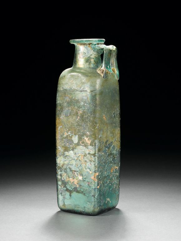 Bonhams : A tall Roman green glass prismatic bottle