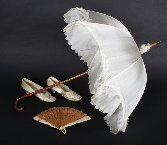 Bonhams : A cream shoe, fan and parasol set