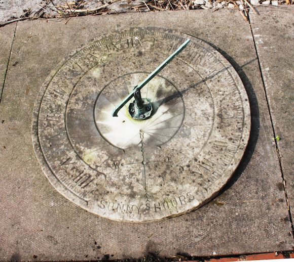 Bonhams : An old weathered white marble circular sundial and a stone trough