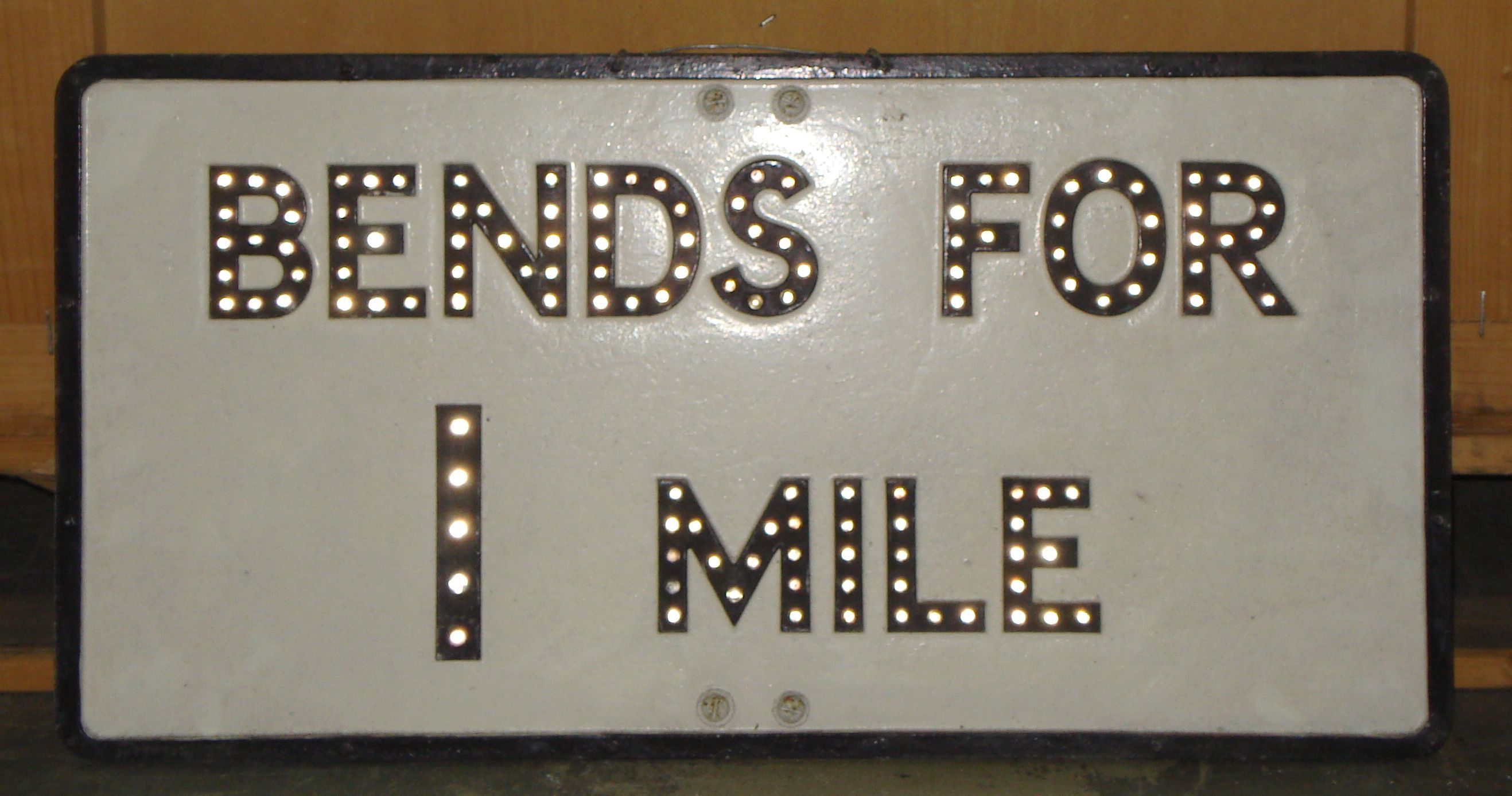 Bonhams Cars : A 'Bends For 1 Mile' cast alloy road sign,