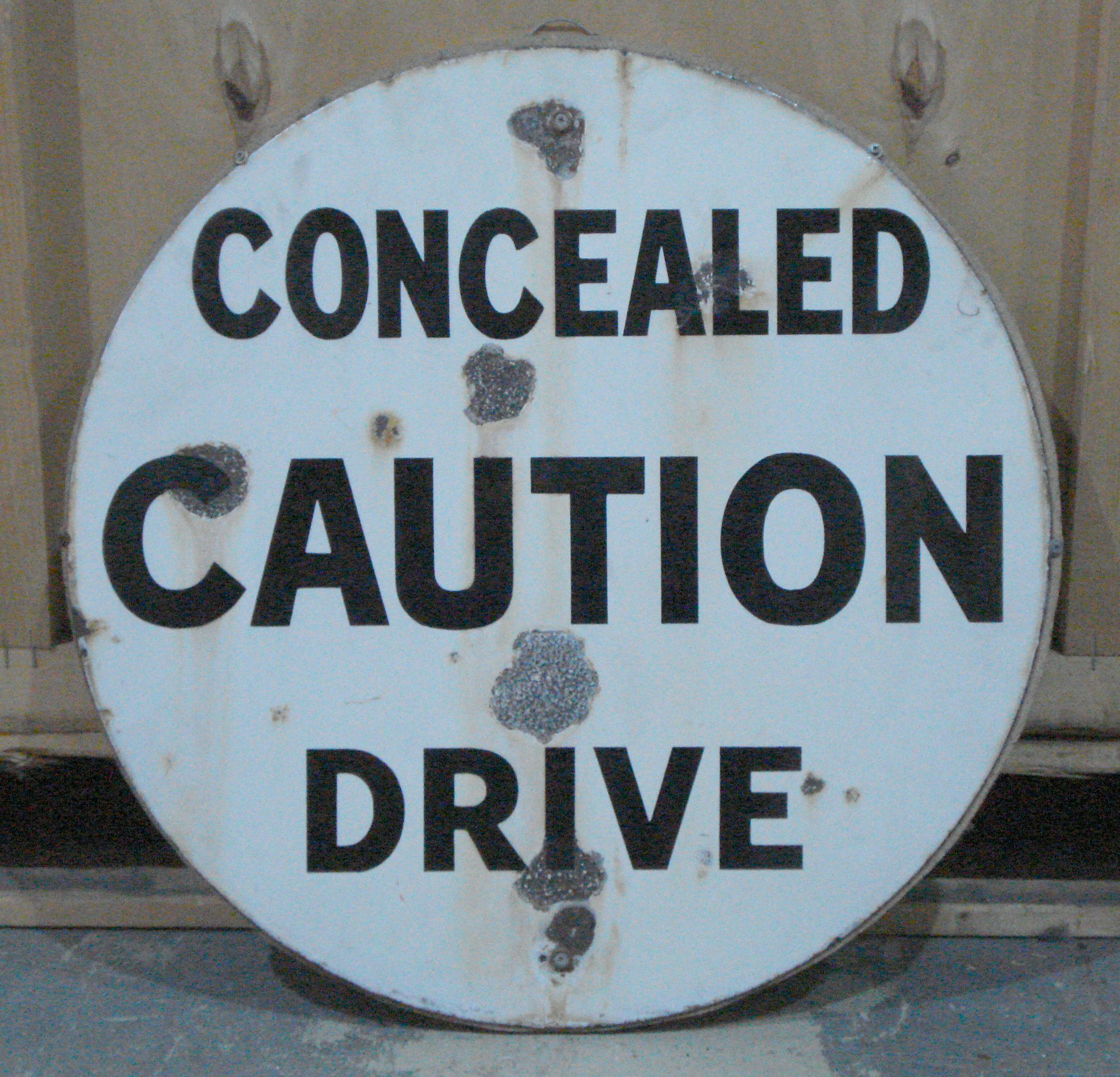 Bonhams Cars : A 'Caution - Concealed Drive' circular enamel sign,