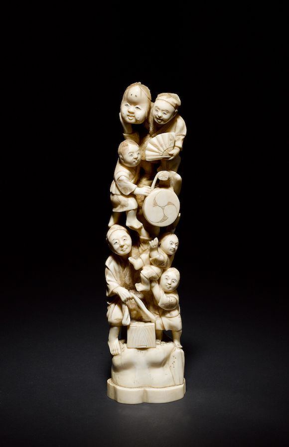 Bonhams : An ivory okimono, carved as a group of boys with a drum and ...