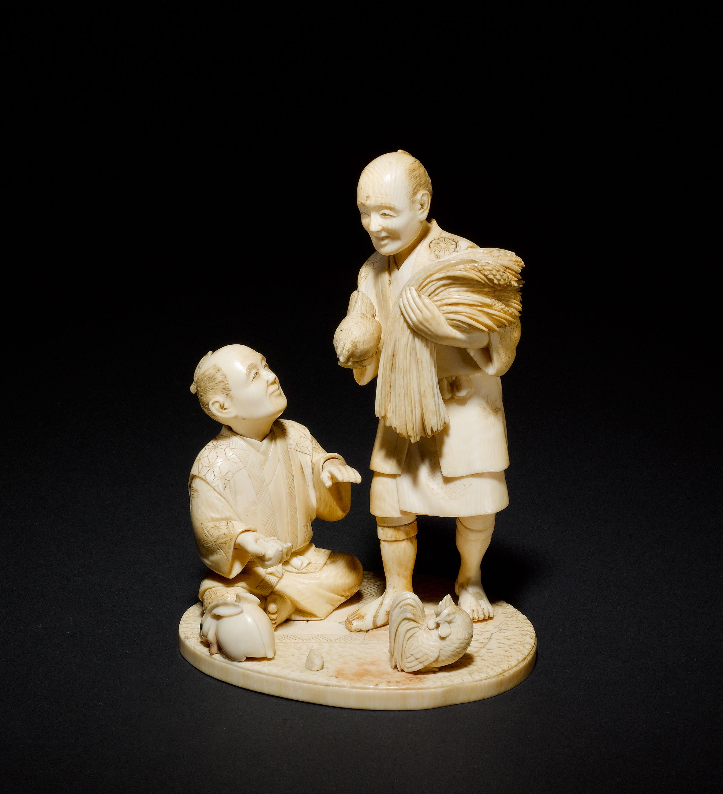 Bonhams : An elegant ivory okimono, carved as two farmers Signed on a ...