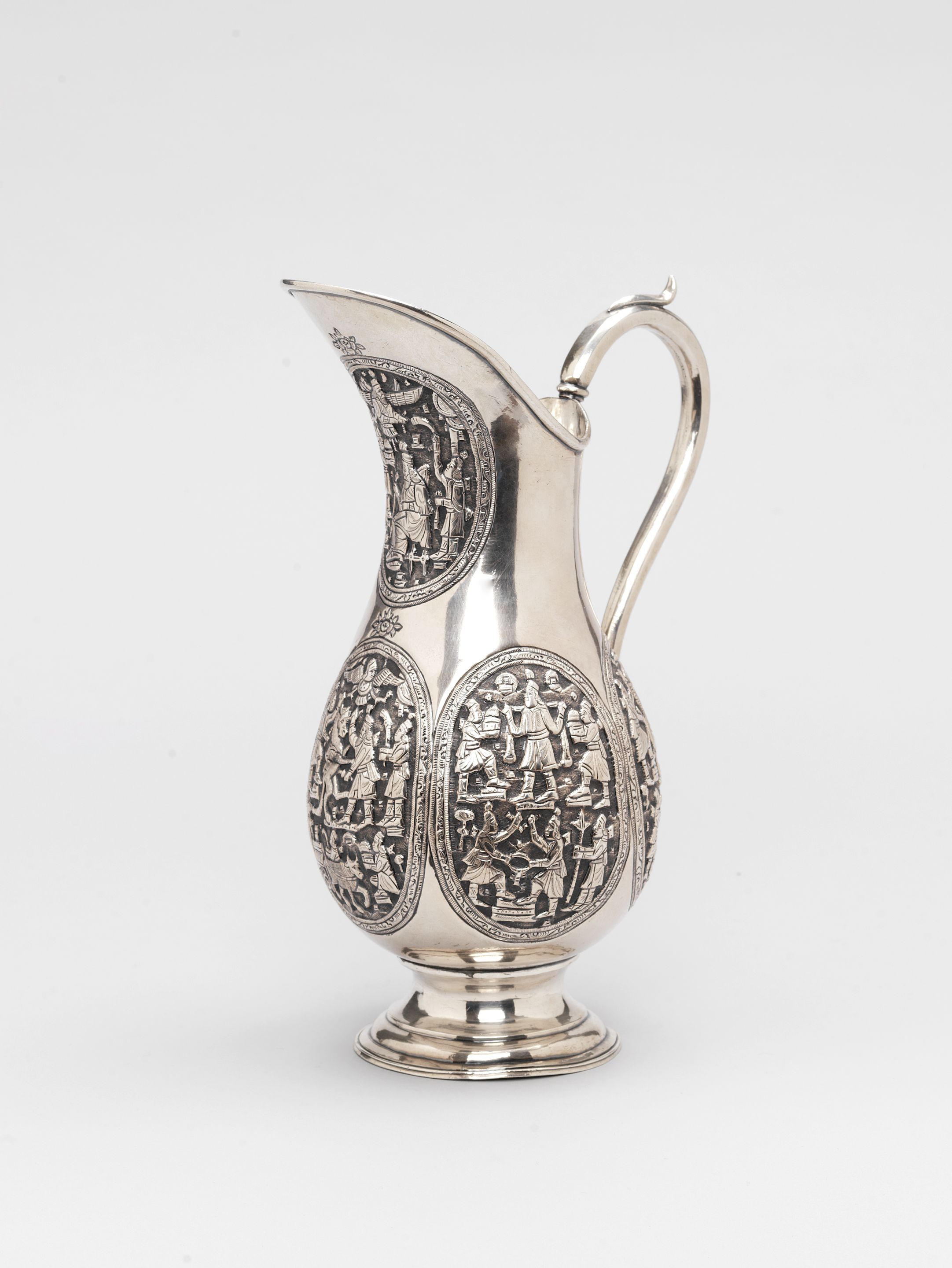 An Achaemenid Revival repousse silver Ewer depicting scenes from ...