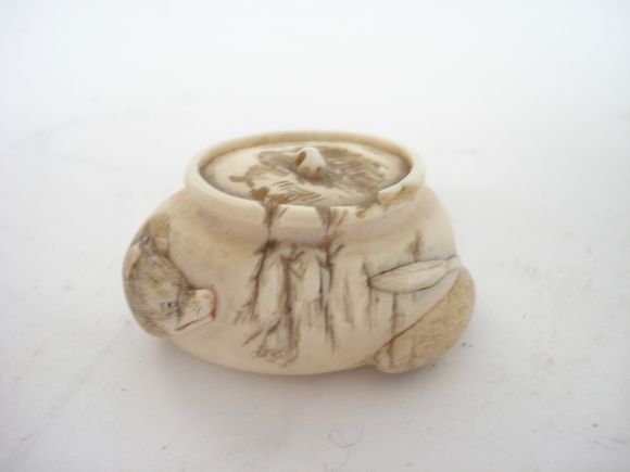 Bonhams : A carved ivory netsuke of a fox and basket