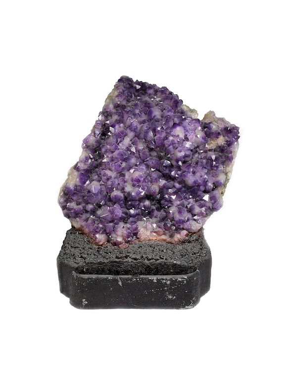 Bonhams : A massive amethyst cluster, on a purpose made decorative base,
