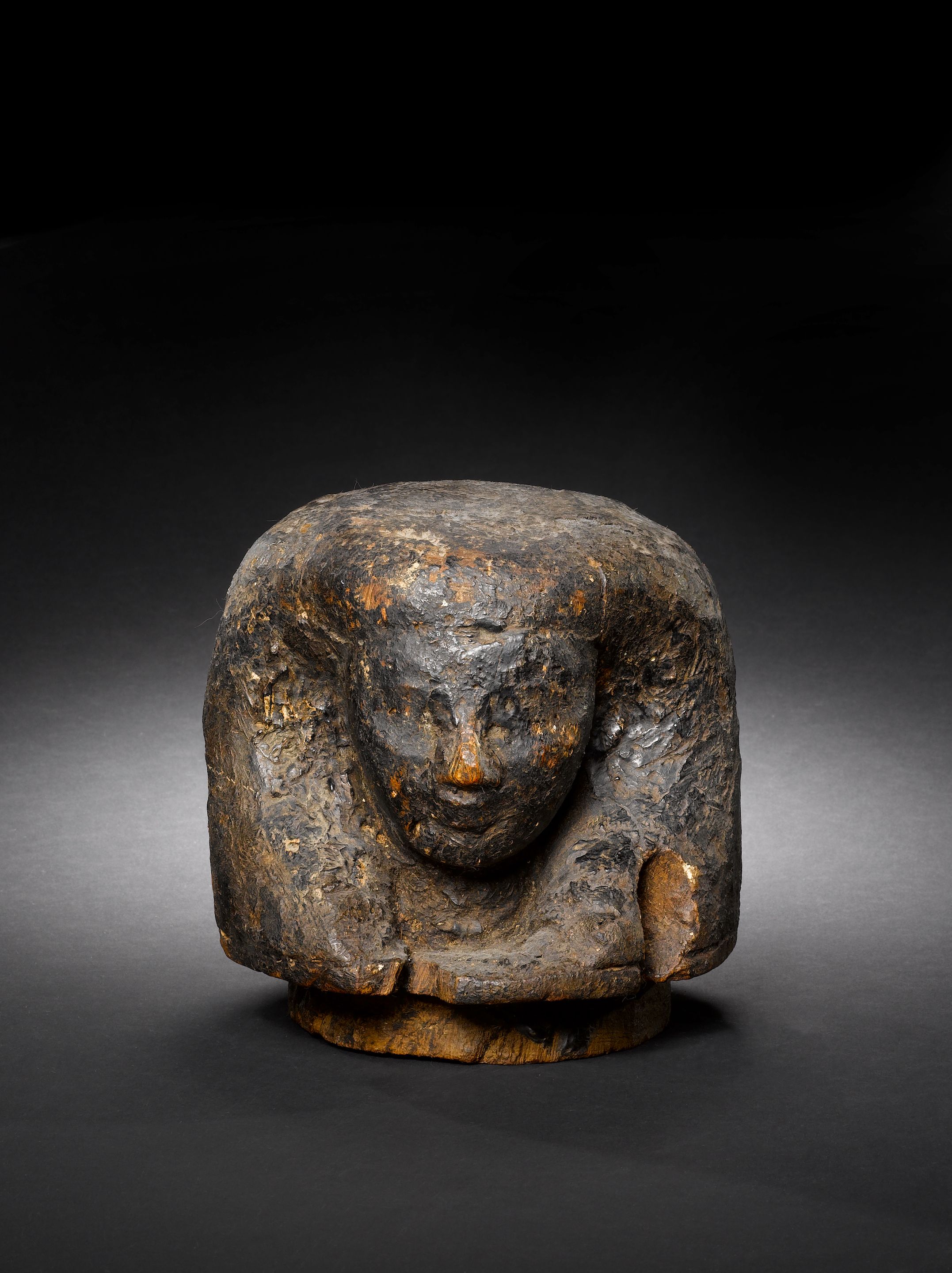 Bonhams : An Egyptian bitumen covered wood canopic jar stopper