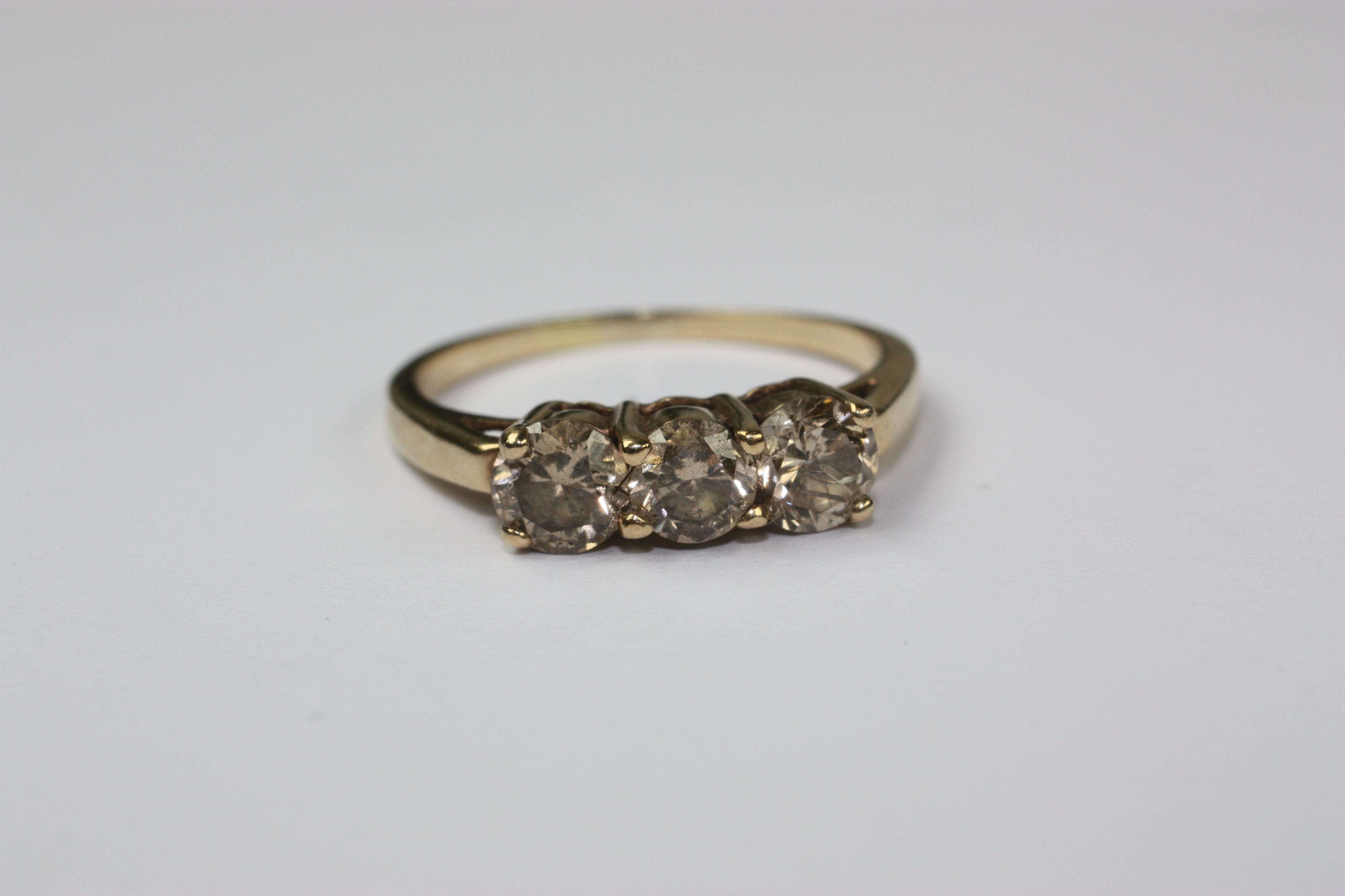 Bonhams : A three stone cinnamon diamond ring,
