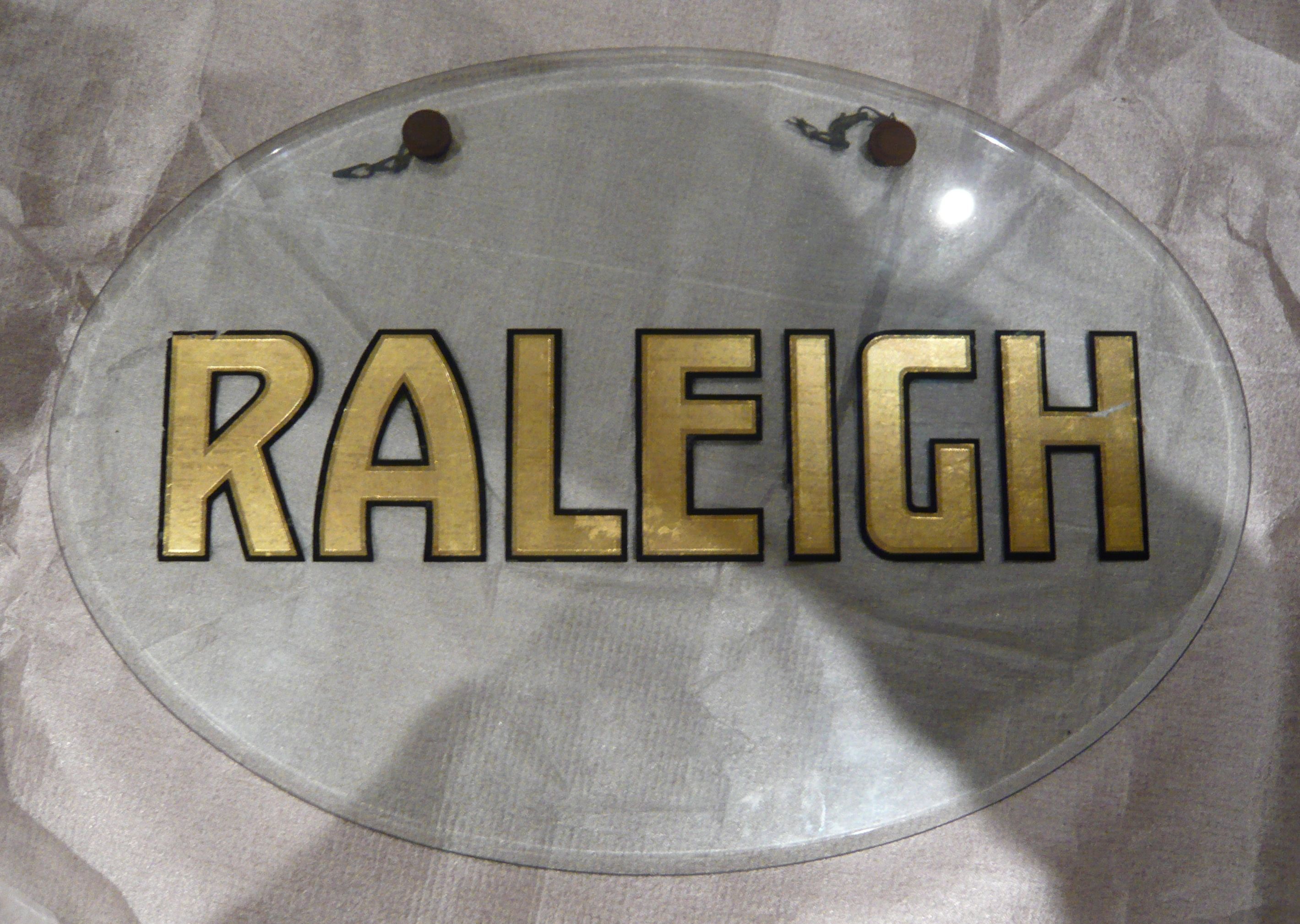 Bonhams Cars : A Raleigh glass oval hanging display sign,