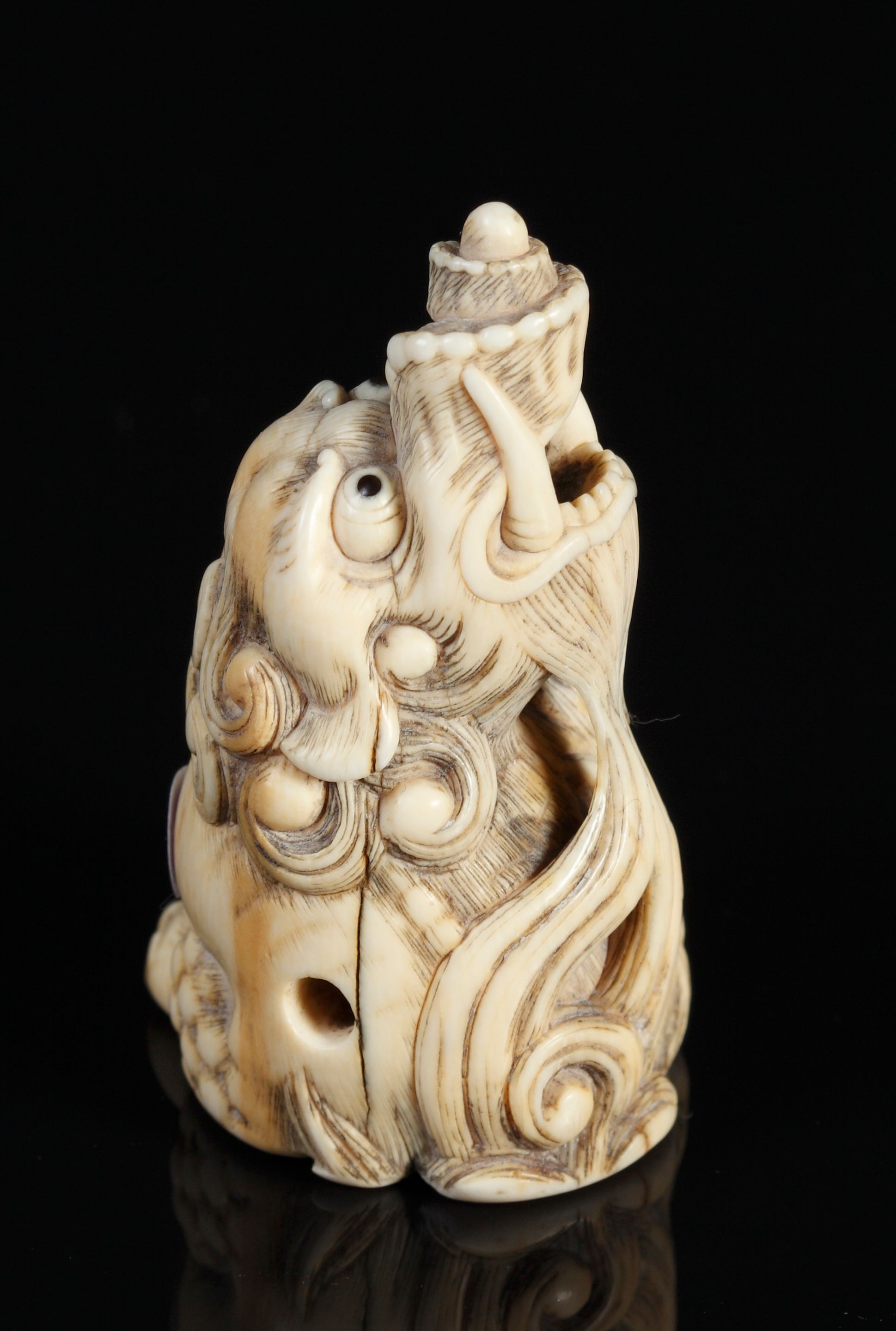 Bonhams : An ivory netsuke of a seated baku