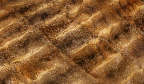 Bonhams : A possum skin rug on green felt backing