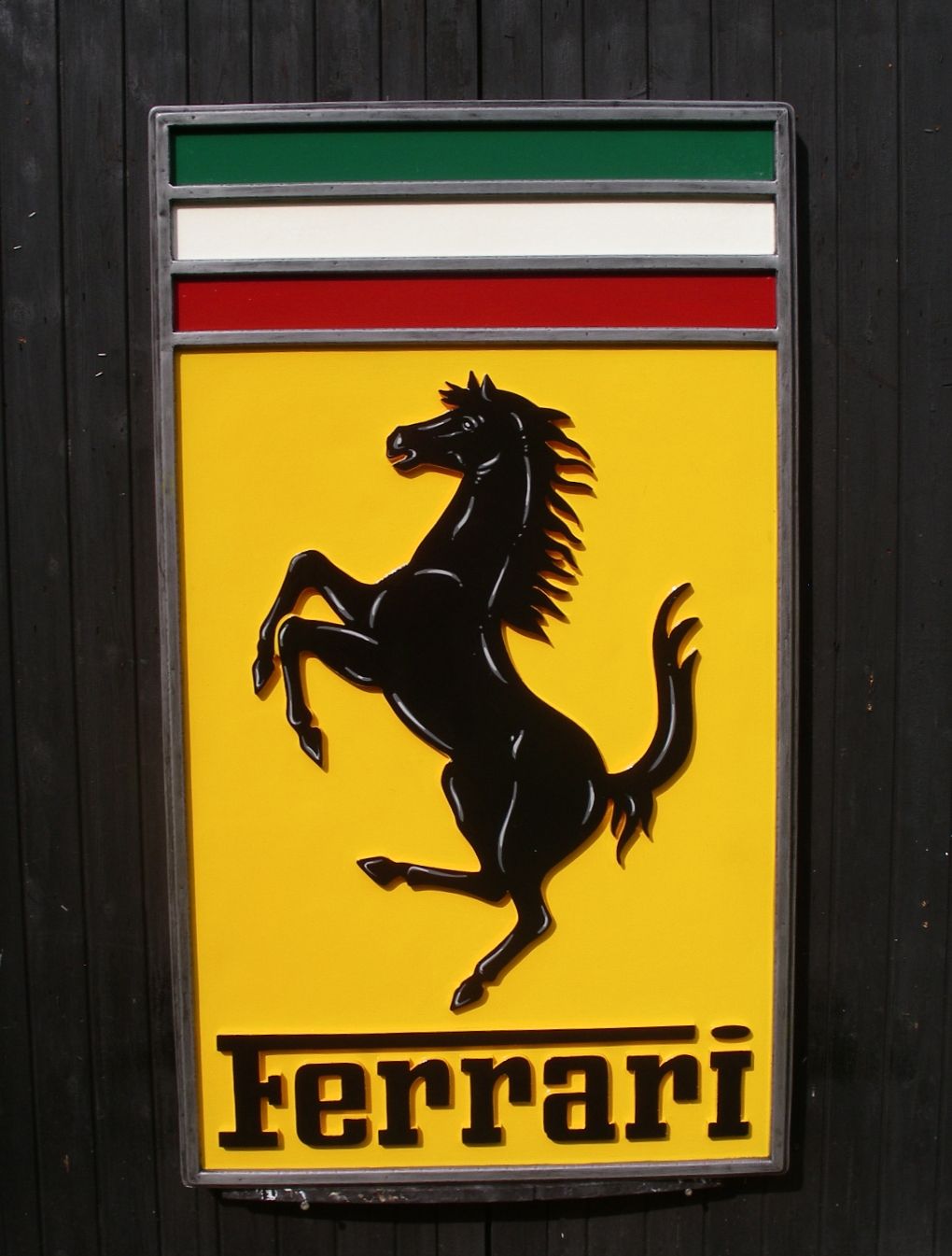 Bonhams Cars : A hand-painted Ferrari garage display emblem,