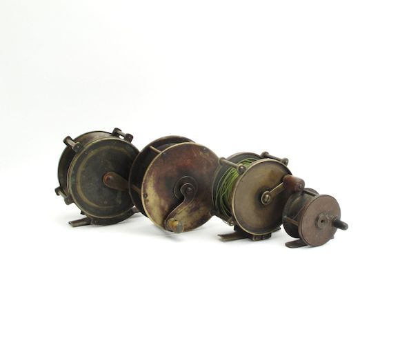 Bonhams : Two early brass reels with raised check and two other brass reels