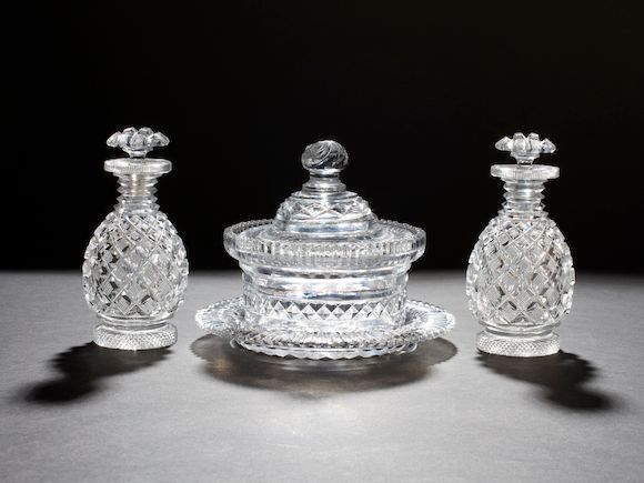 Bonhams : A cut glass butter tub, cover and stand and two perfume ...