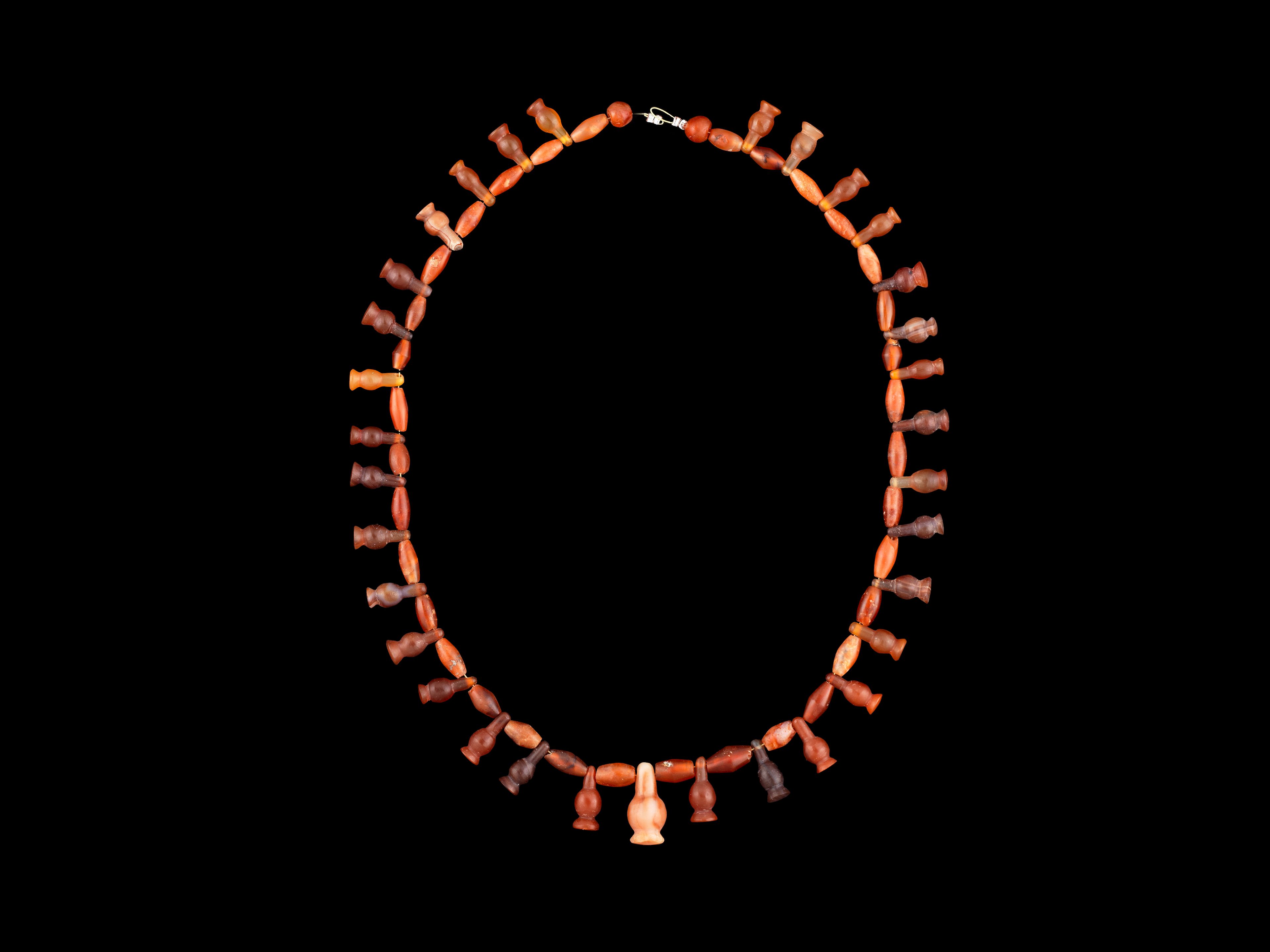 Bonhams : An Egyptian carnelian poppy head amulet necklace