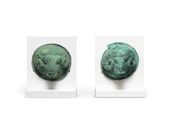 Bonhams : Two Etruscan bronze votive shield bosses with rams' heads