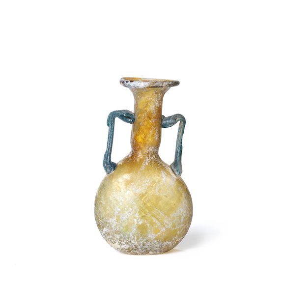 Bonhams : A Roman yellow-amber glass ribbed lentoid flask with blue handles