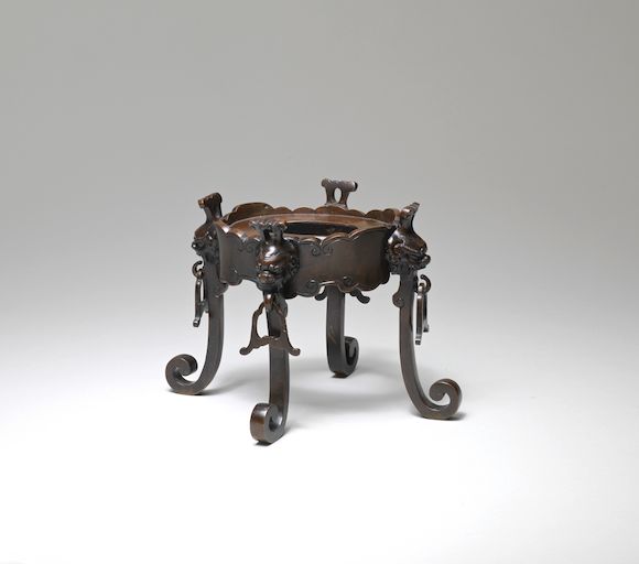 Bonhams : A BRONZE FOUR-LEGGED 'MYTHICAL BEAST' STAND Late Ming Dynasty