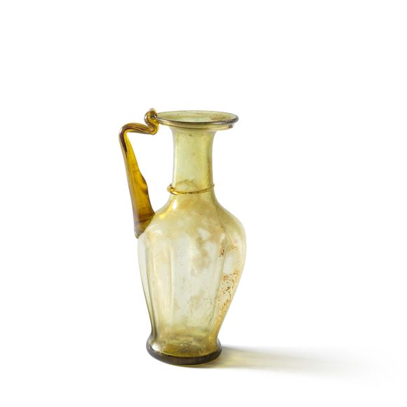 Bonhams : A Roman yellow green dimpled glass jug
