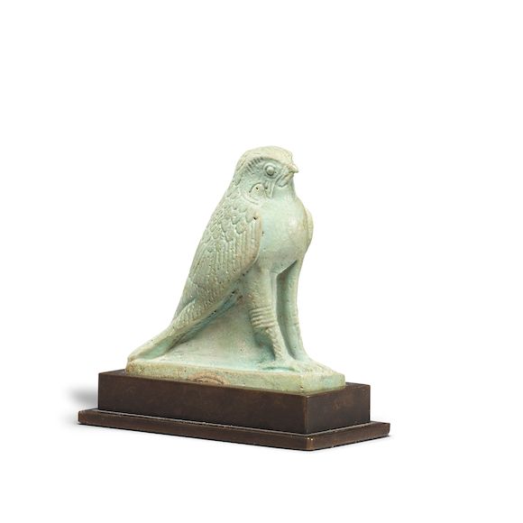 Bonhams : An Egyptian pale green faience statuette of a falcon