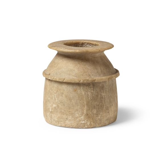 Bonhams : A Mesopotamian alabaster jar with flanged shoulder and disc rim